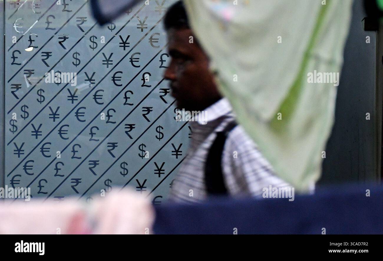A man walks past a door of a foreign exchange office etched with ...