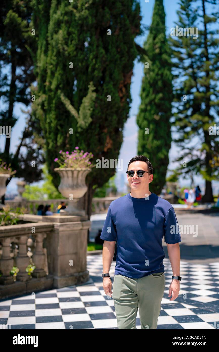 Happy young Latino man with short hair and sunglasses walks calmly over ...