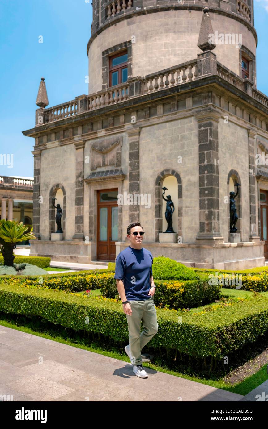 Happy young Latino man wearing navy shirt, light green pants and ...