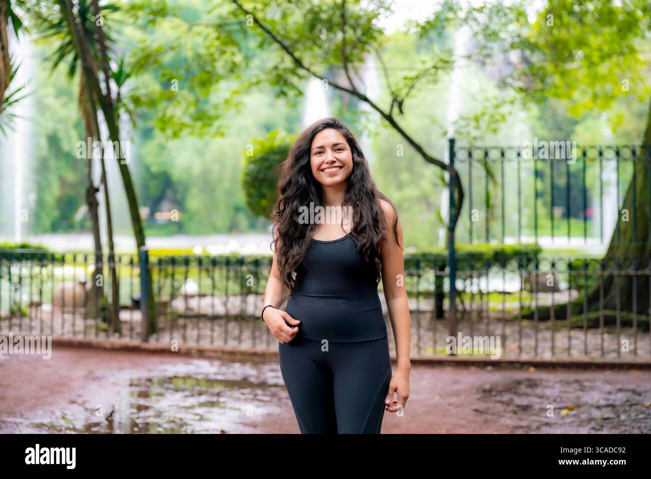 Smiling athletic young Latin woman enjoying a walk in Parque México ...