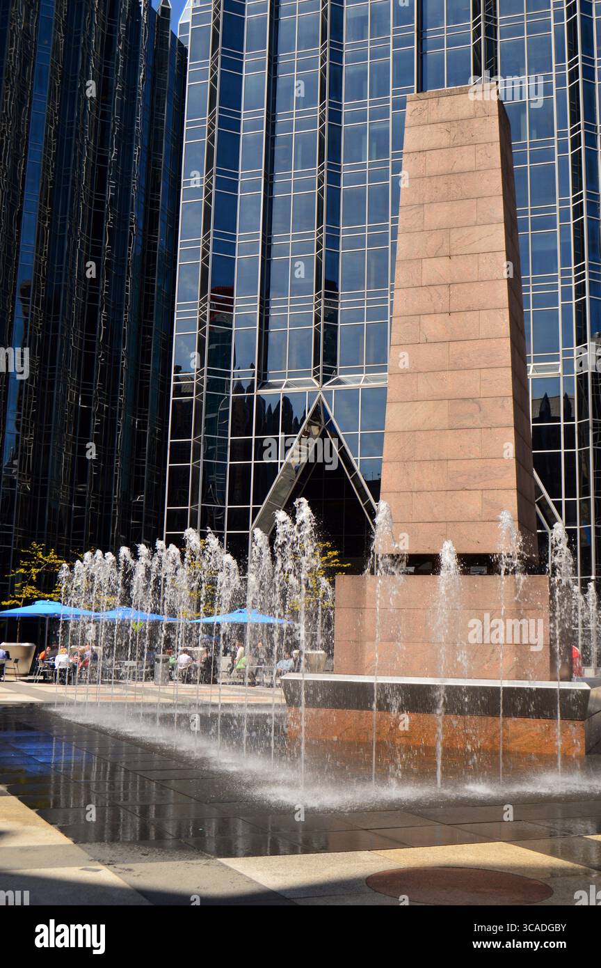A large stone obelisk sits in the center of a water fountain in PPG ...