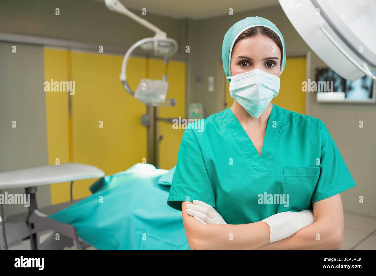 Female surgeon folding arms in operating room with table, surgical lamp ...