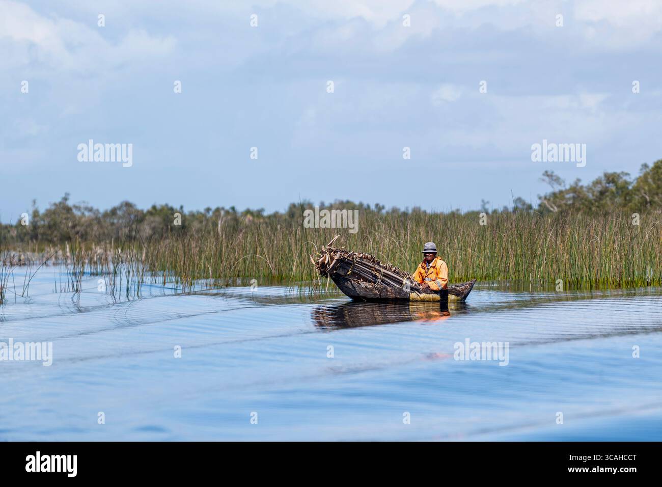 Traditional fisherman paddling a wooden canoe on the Pangalanes Canal ...