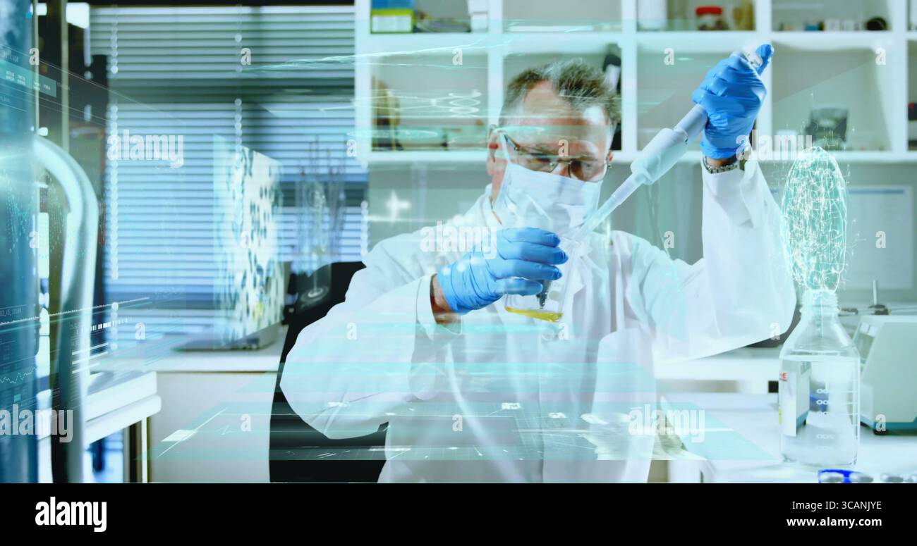 Pipetting yellow solution into beaker, senior scientist wearing lab ...