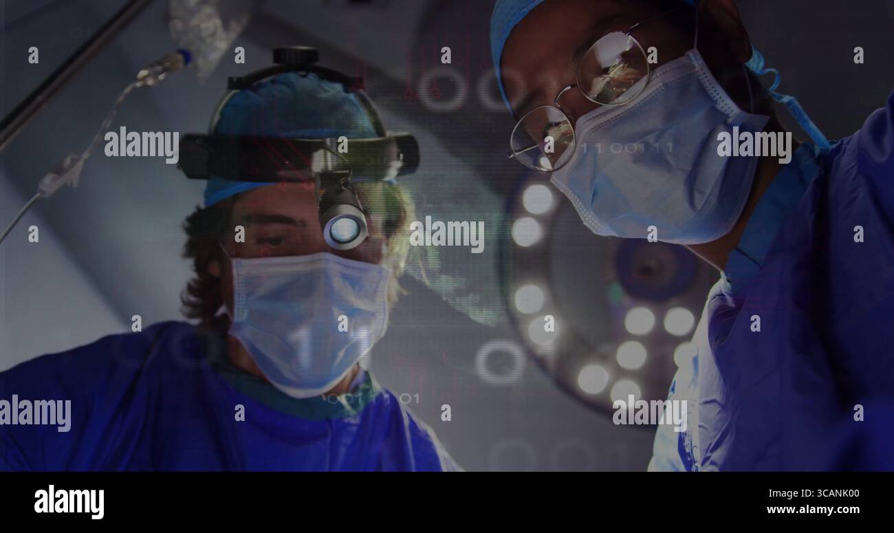 Two surgeons in blue scrubs operating in operating room, with overhead ...