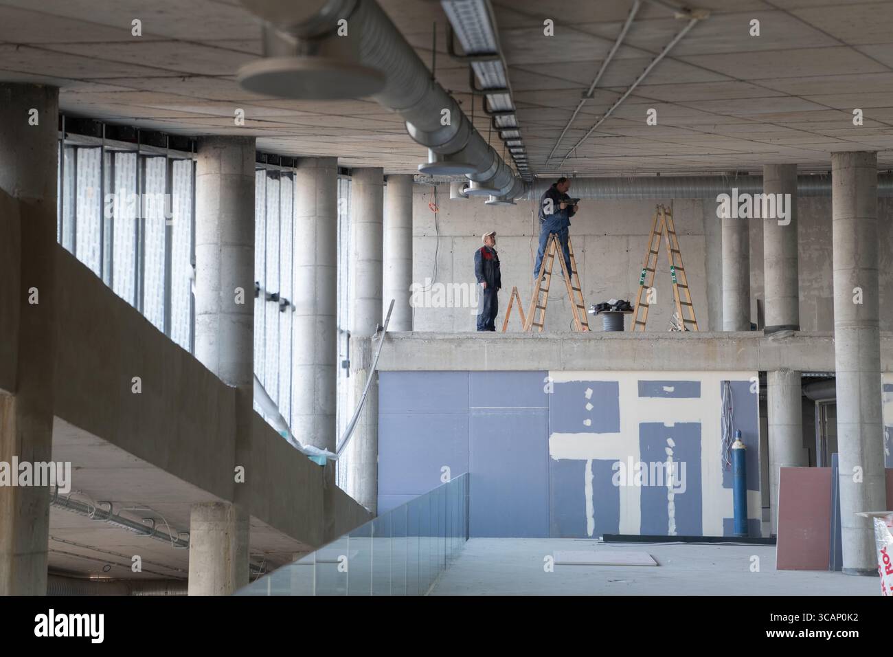 A team of workers collaborates to install a modern ventilation system ...