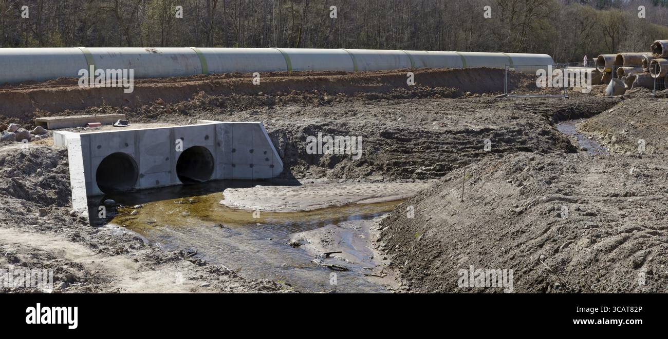 Large concrete sewer pipes and heaps of sand with traces of heavy ...