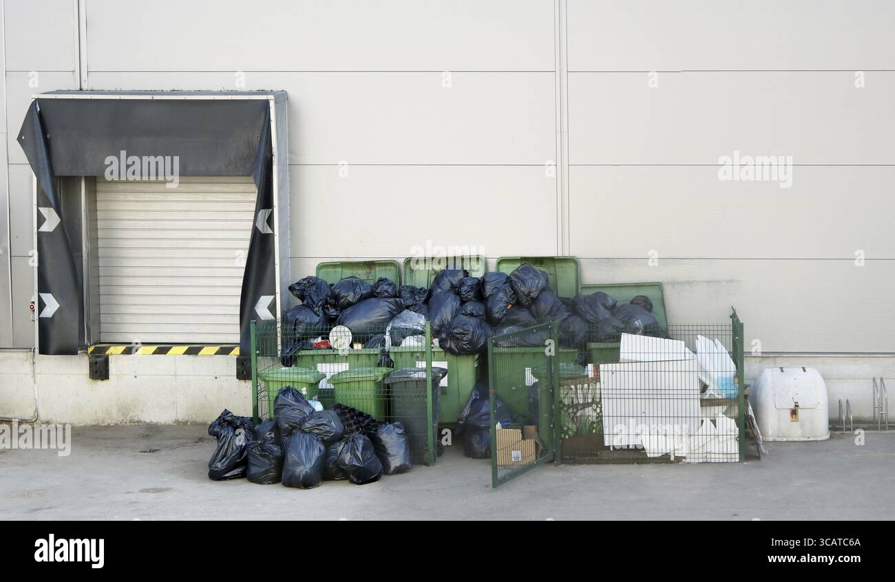 Green garbage containers with black plastic bags near the large food ...
