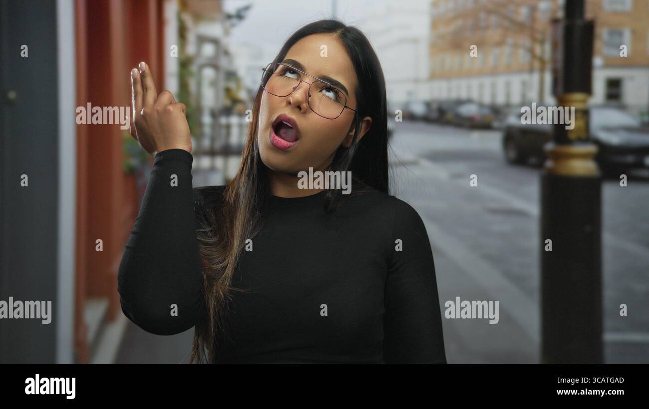 Urban portrait of a woman making a hand gesture in a street scene, a ...