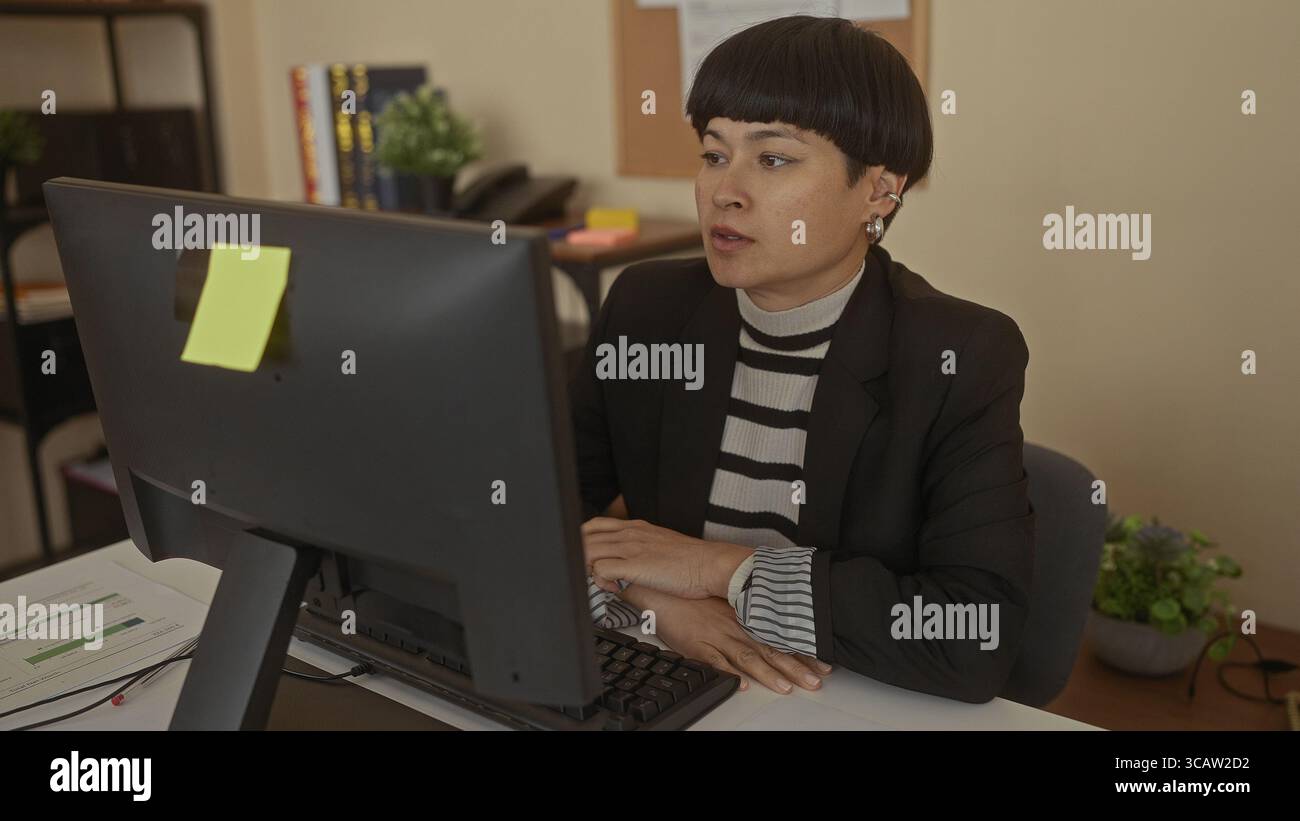 Woman working in an office, checking her phone and awaiting time while ...