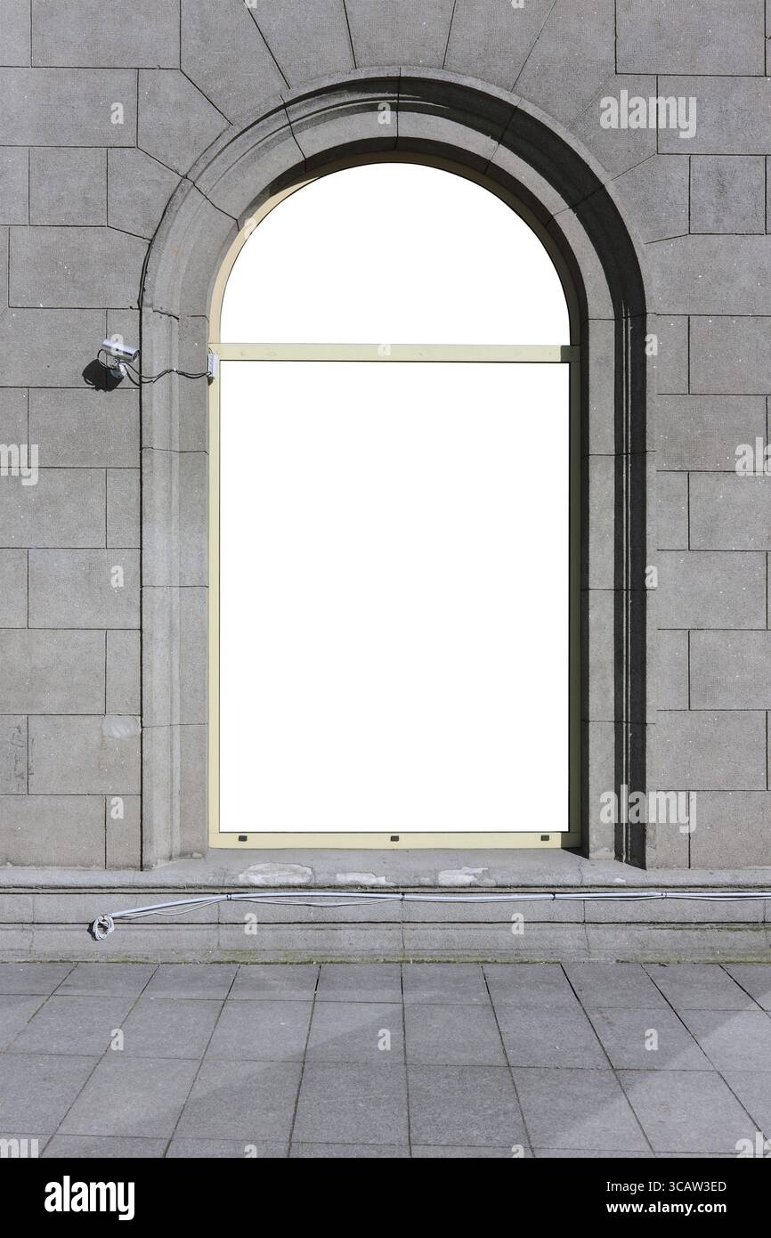 Big arch window in a granite wall of the old house. The video camera ...