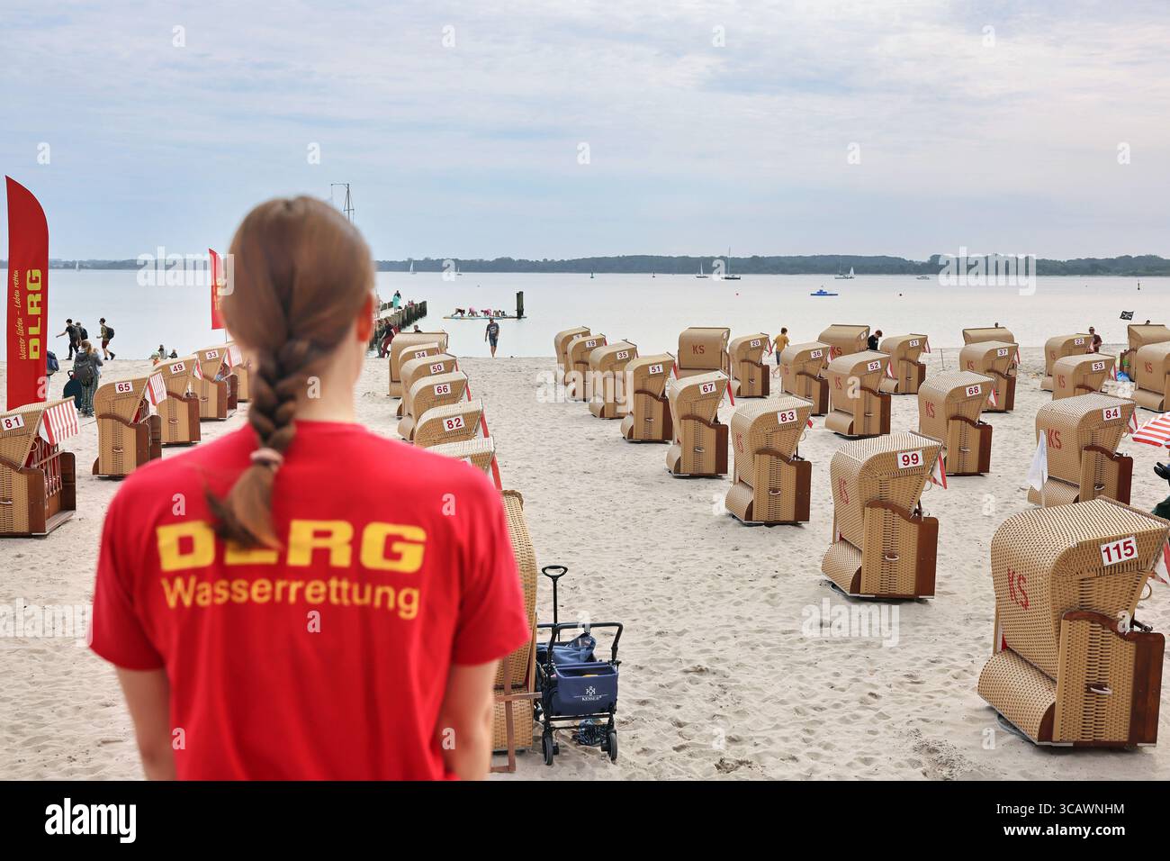 07 August 2025, Schleswig-Holstein, Travemünde: A lifeguard observes ...