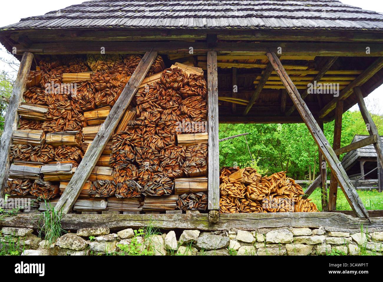 Prepared roofing material stacked in an open shed: wooden planks for ...
