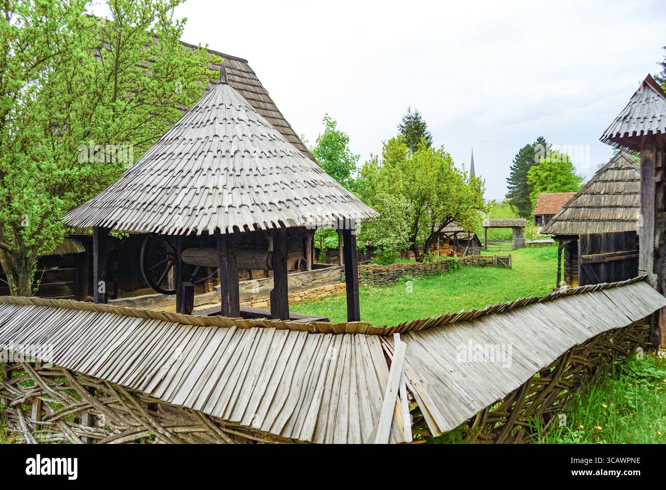 Romanian village courtyard with a wicker fence, a well under a canopy ...
