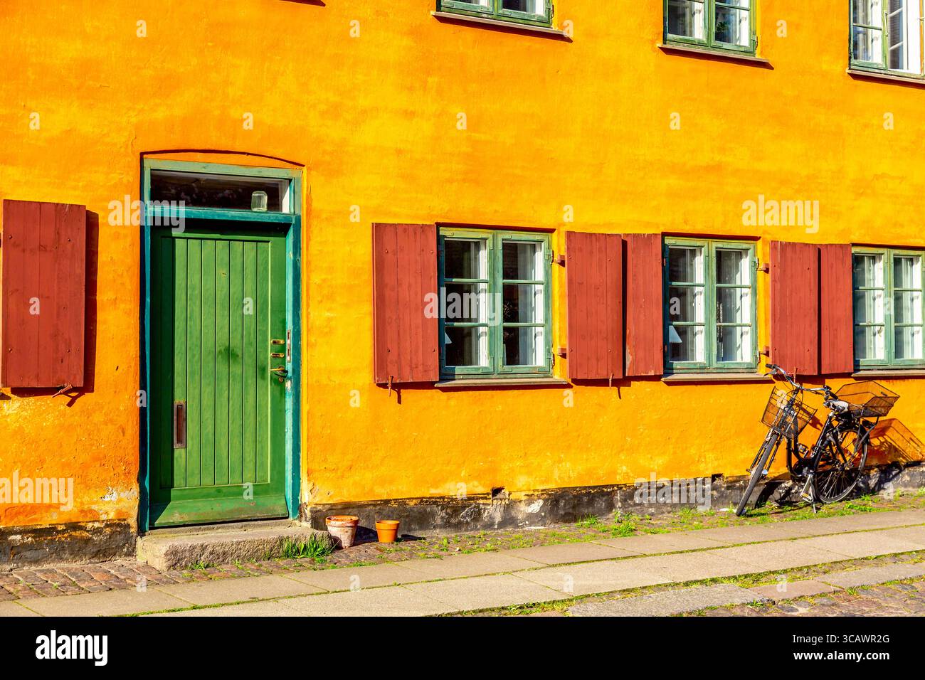 Old yellow house of Nyboder district with a bicycle. Old Medieval ...