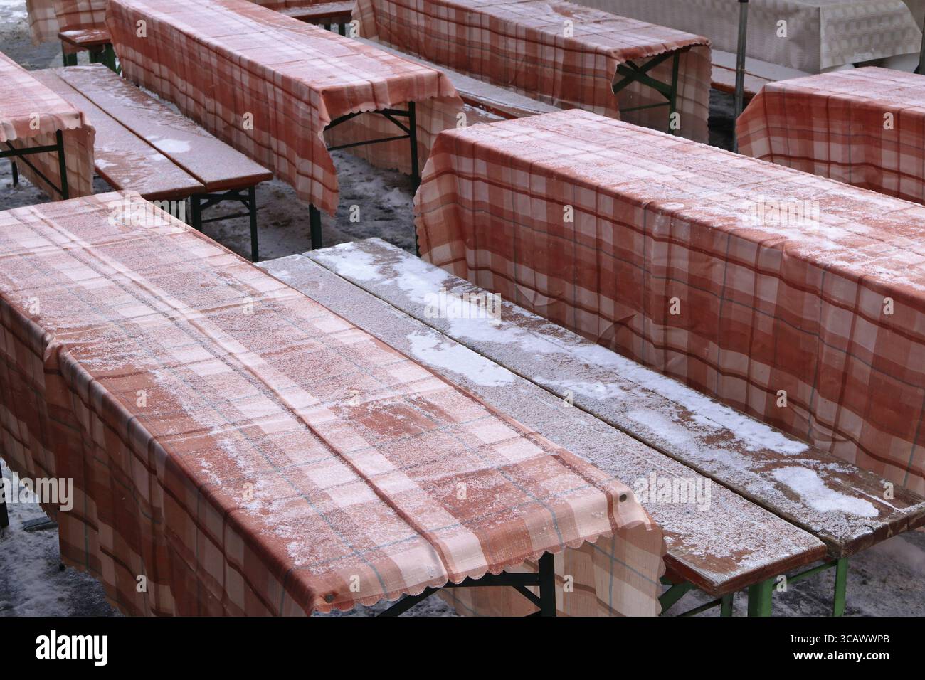 On the tables and benches of the street cafe lies cold snow. WInter ...