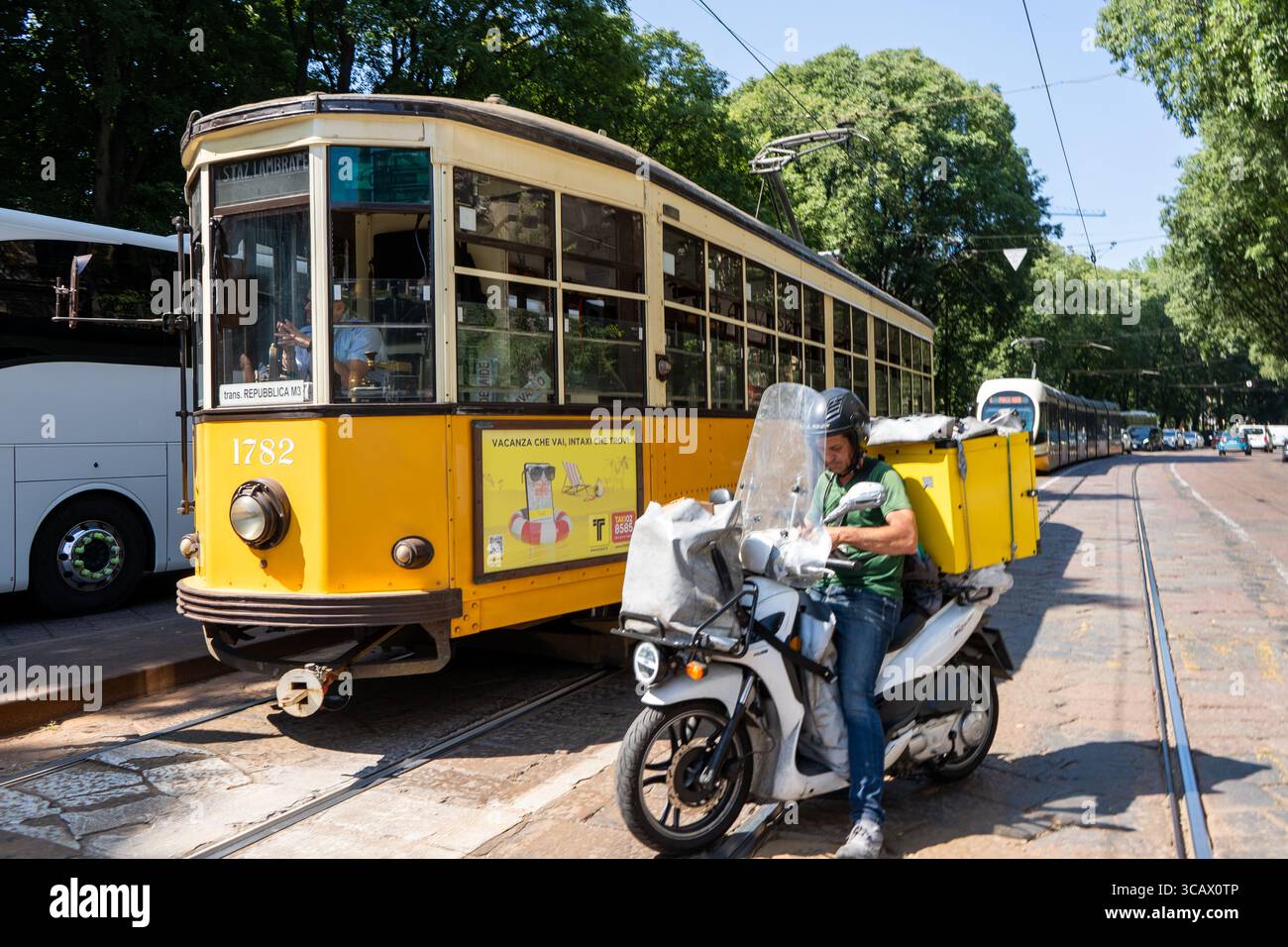 Old yellow Italian tram. Driver motorcycle delivery Glovo. Traffic jam ...