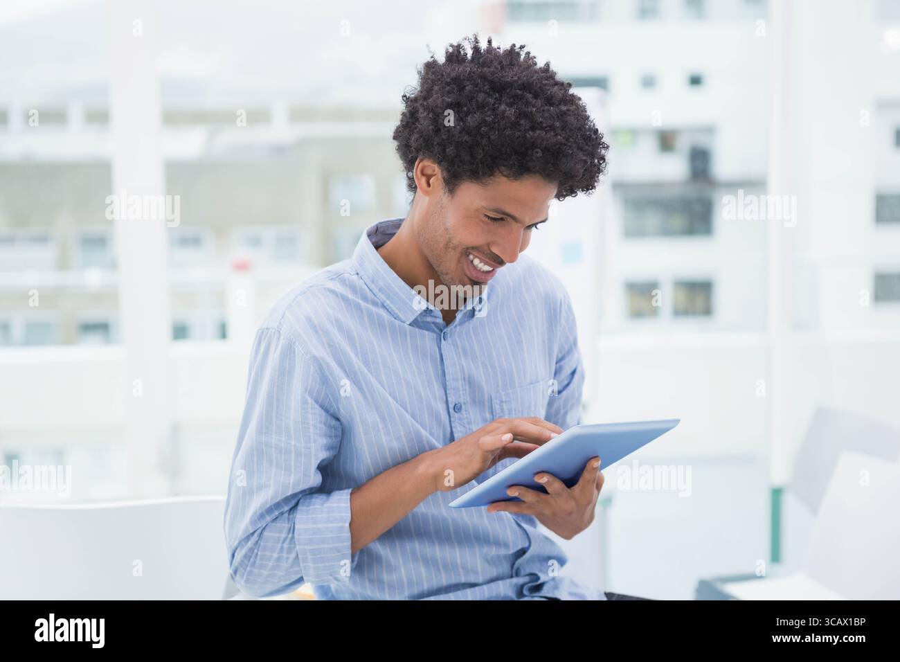 African American man tapping tablet screen while sitting by large ...