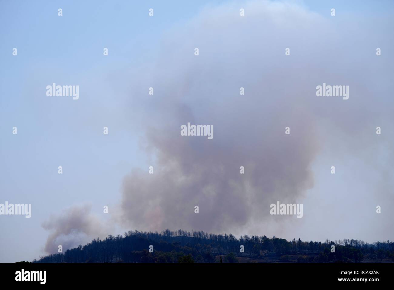 Smoke billows behind a hill during France's largest wildfire in decades ...