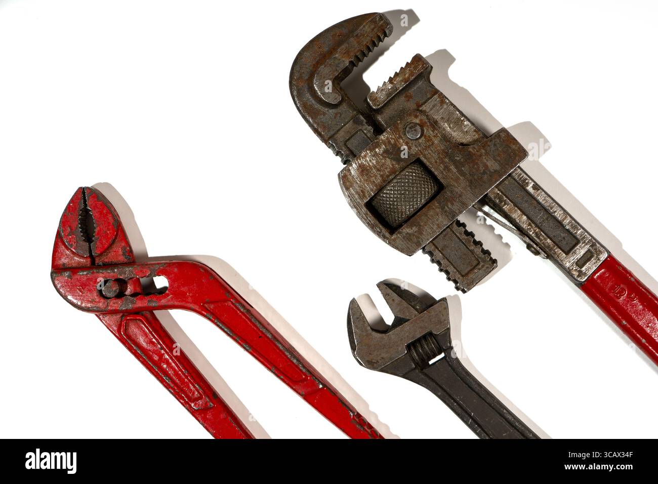 Old rusty and red tools lying on a white background, ready to be used ...