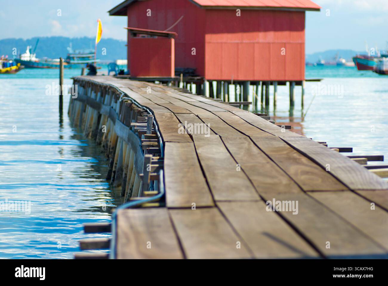 Curved Wooden Jetty Leading to Red Waterfront Stilt House Over Calm Sea ...