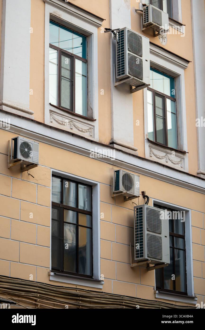 Facade of building with many air conditioners on windows in southern ...