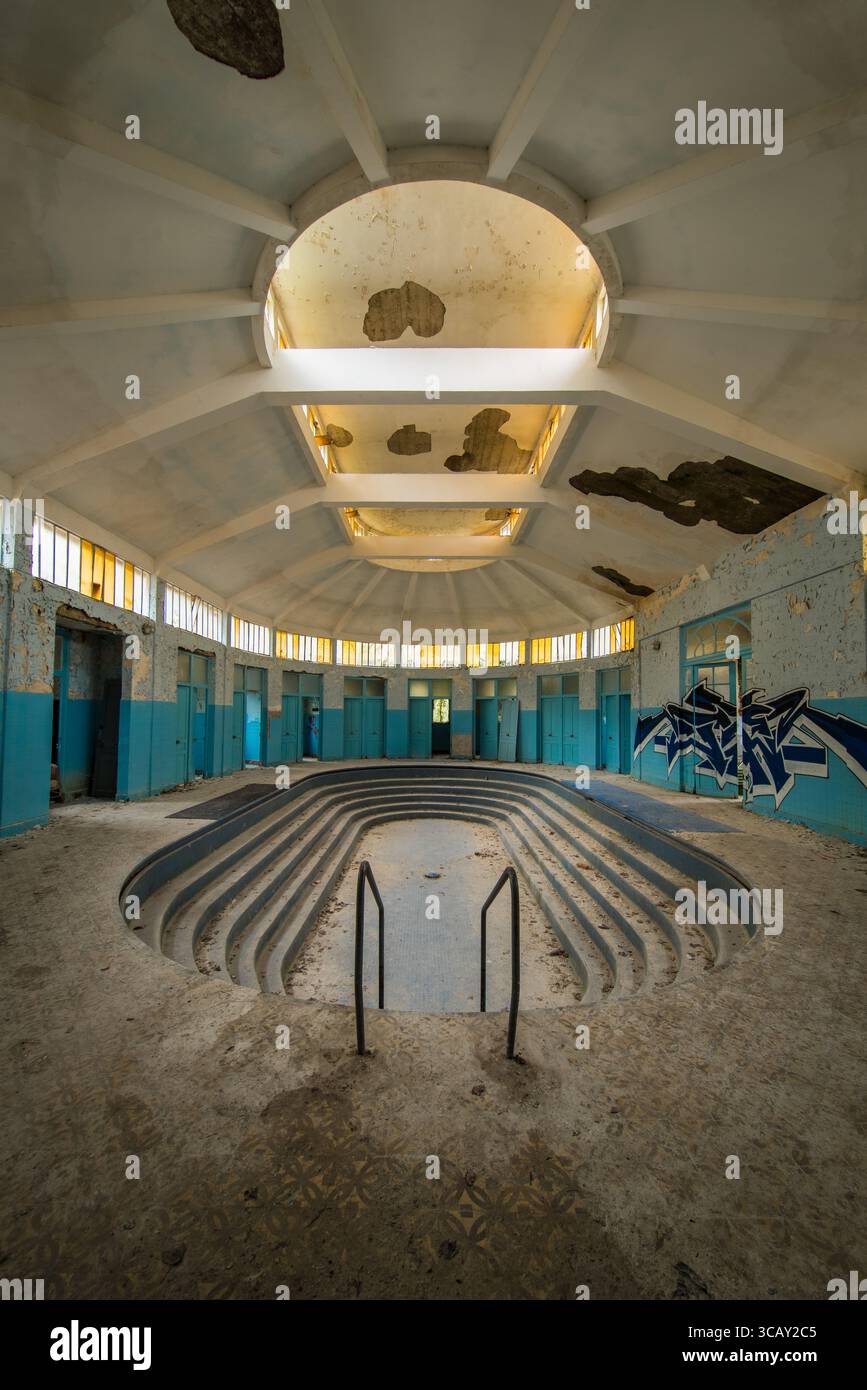 Abandoned indoor pool with peeling paint and graffiti in a historic ...