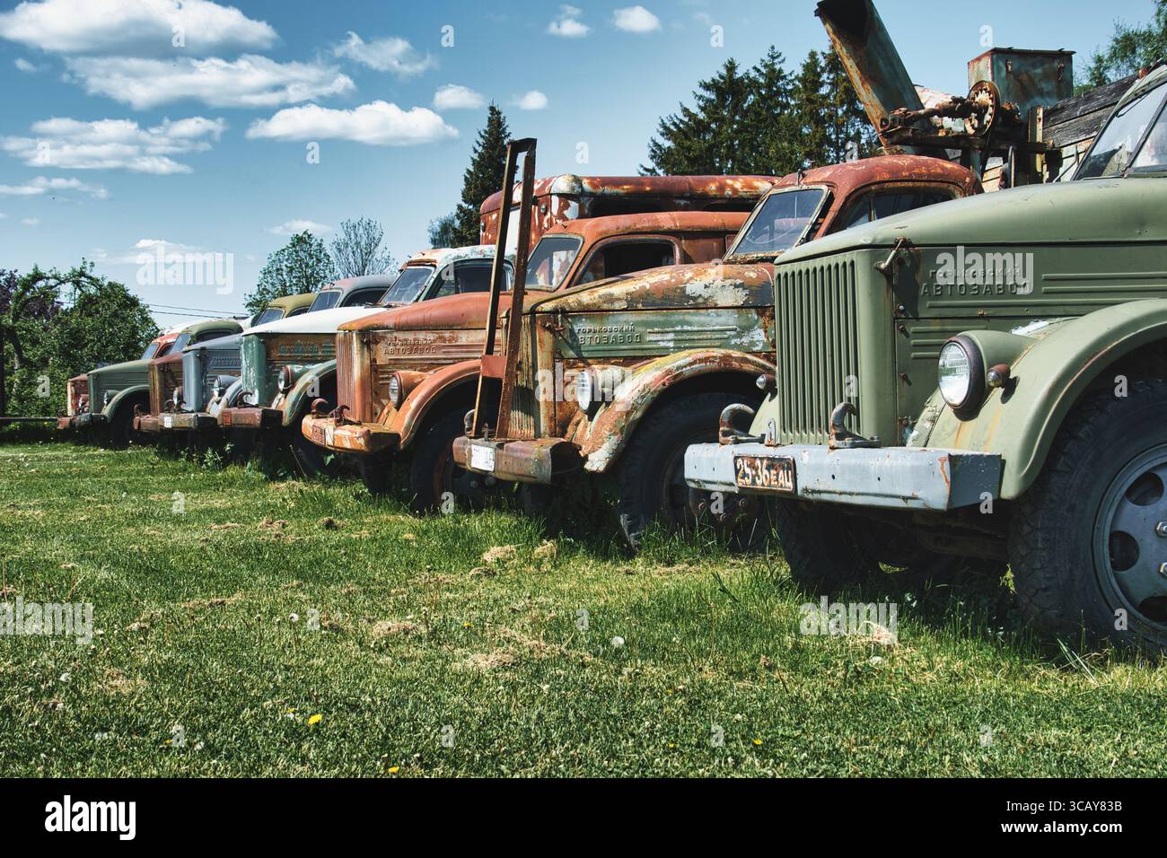 Line of Vintage Soviet Trucks Rusting in a Field Under Blue Sky Stock ...