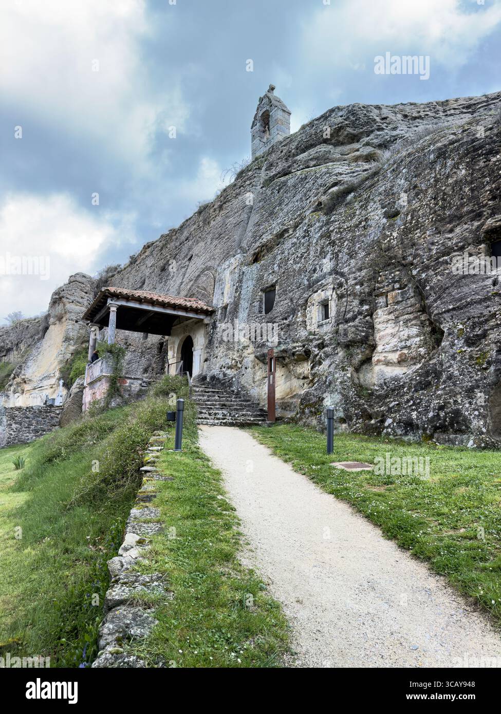 Exterior view of church carved into rock face with path, bell gable ...
