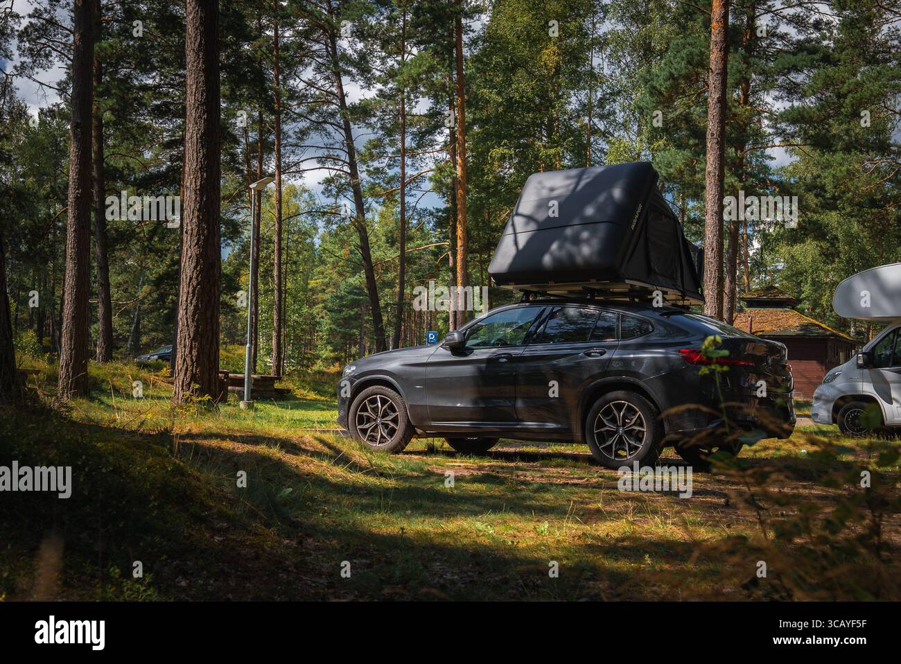 BMW X4 2025 with Rooftop Tent in a Forested Camping Area Stock Photo ...