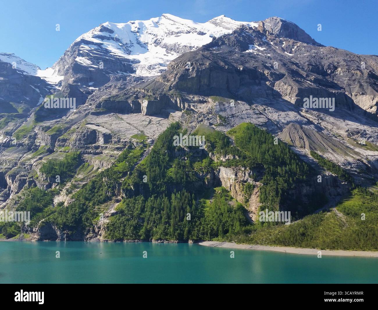 Lake Oeschinen with snow covered mountains of the Swiss Alps and bright ...