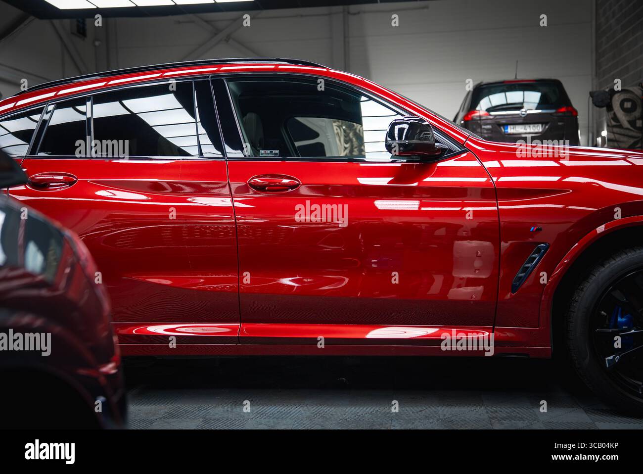 Red BMW X4 and Black Range Rover Discovery in Modern Garage Stock Photo ...