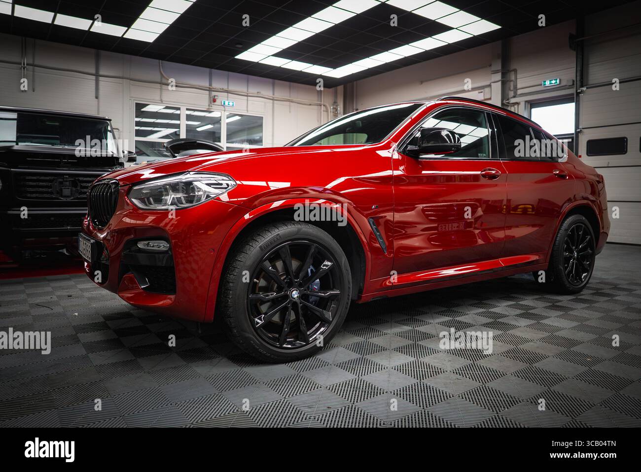 Red BMW X4 and Black Mercedes G Class in Modern Car Shop Garage Stock ...