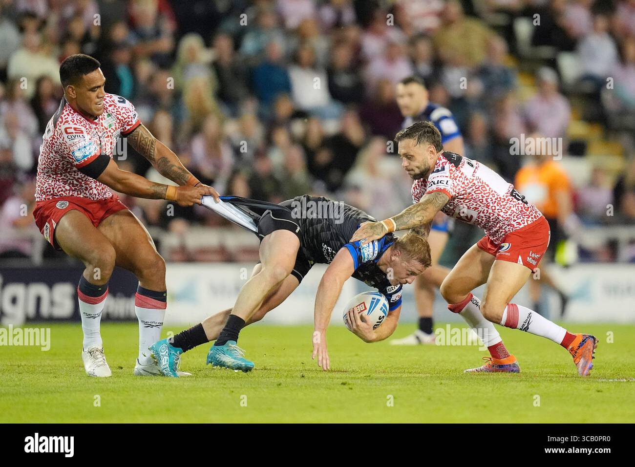 Leeds Rhinos' Lachlan Miller (centre) is tackled by Leigh Leopards' Joe ...