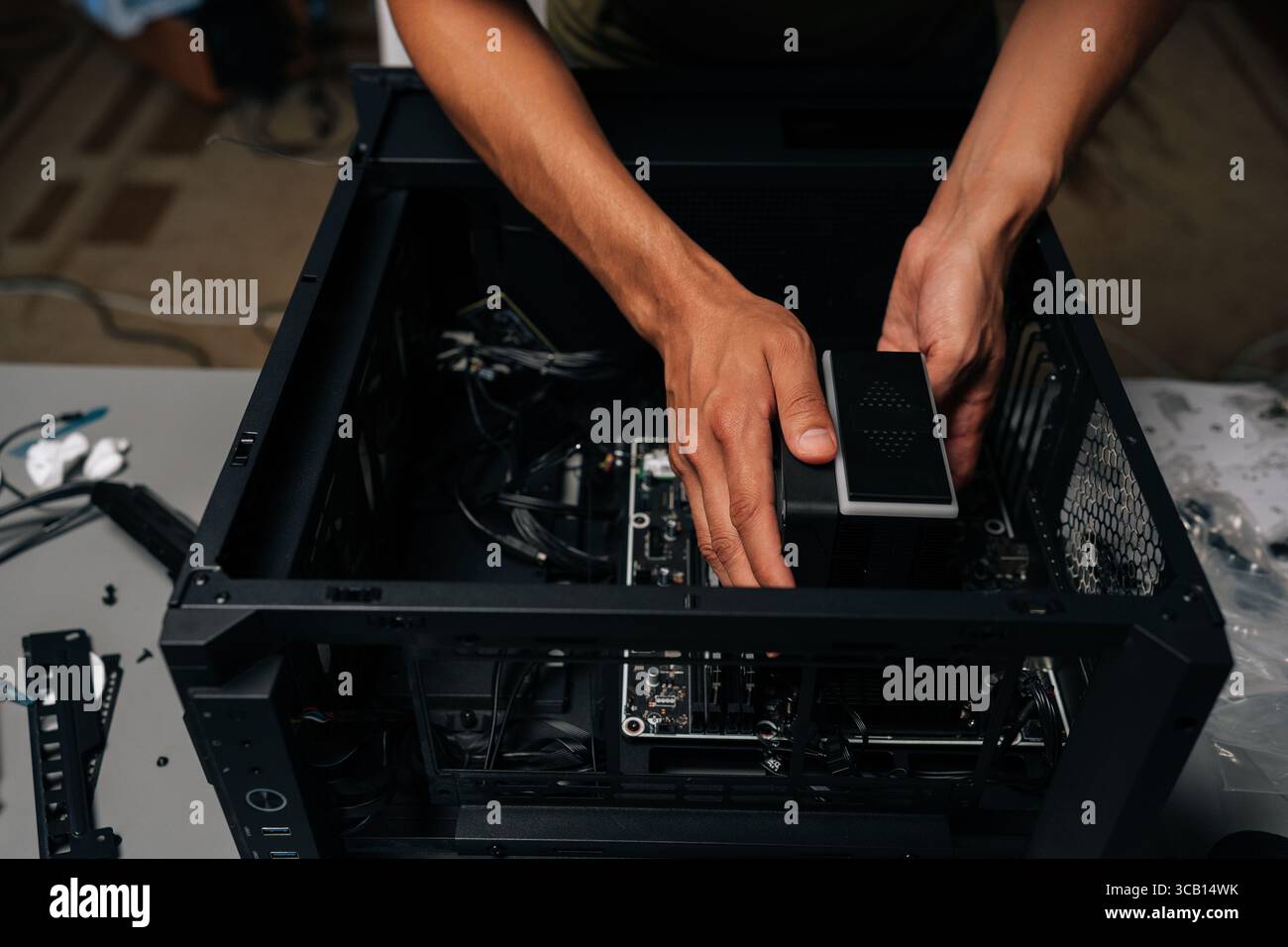 Close-up cropped shot of technician installing CPU water cooler into desktop computer case ...