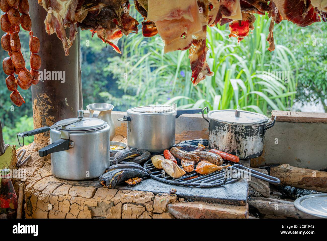 Rustic outdoor kitchen in Colombia with hanging smoked meats and ...