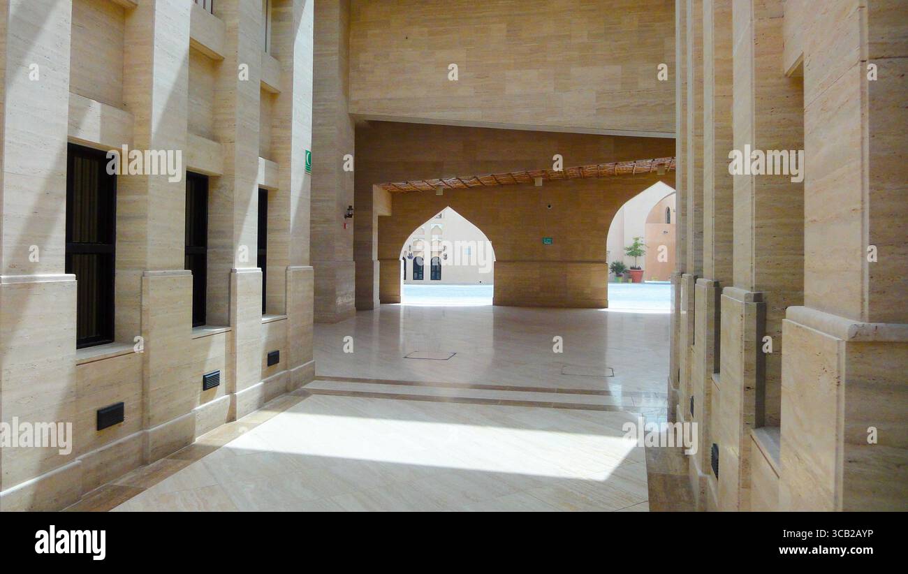 A wide, modern walkway with arches and light stone architecture in ...