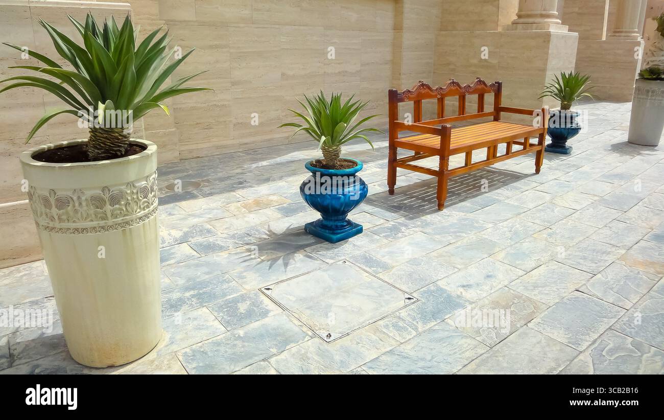 Decorative wooden bench and potted plants in a serene courtyard at ...