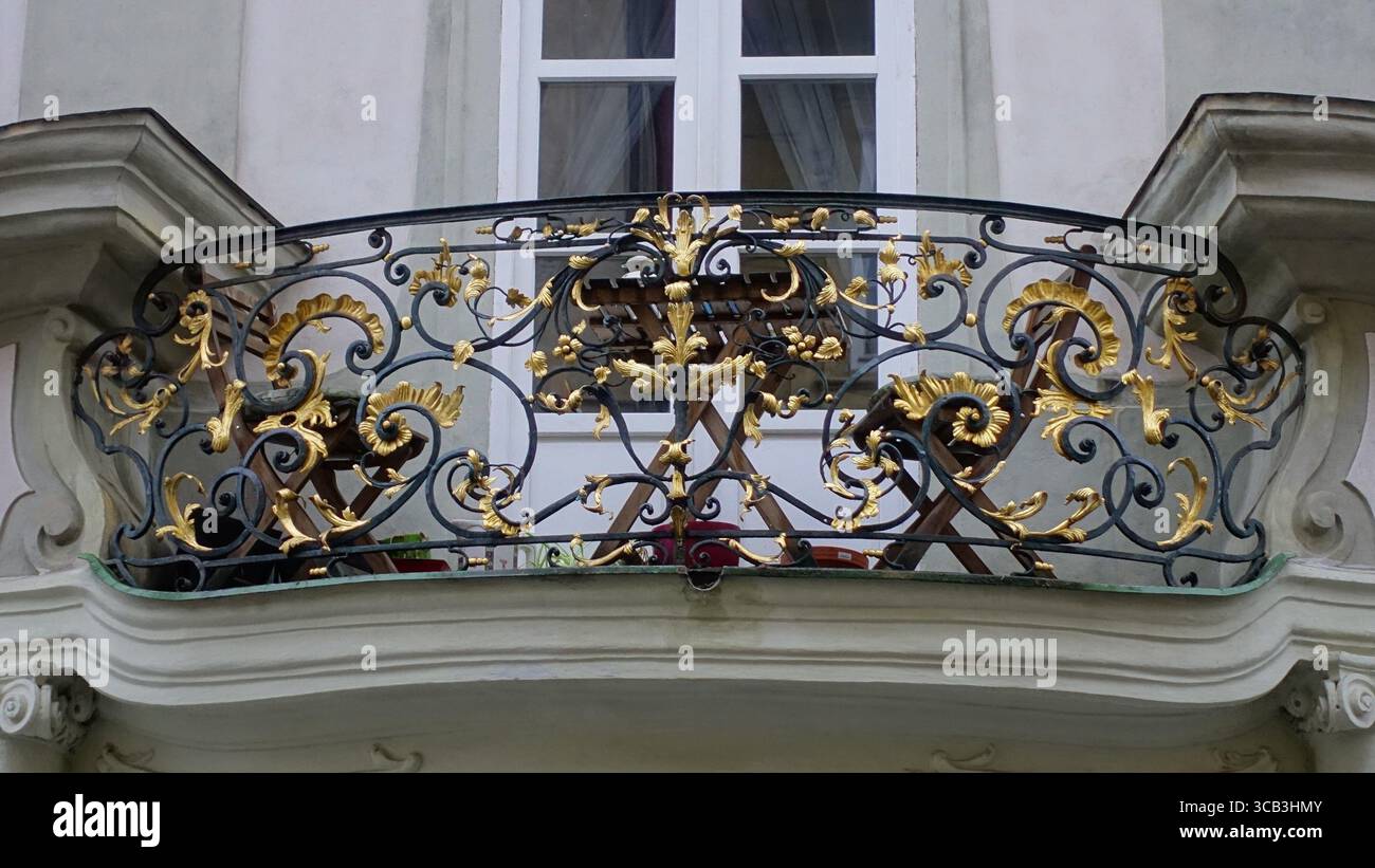 Elegant balcony grille with gilded openwork forging of an ancient house ...