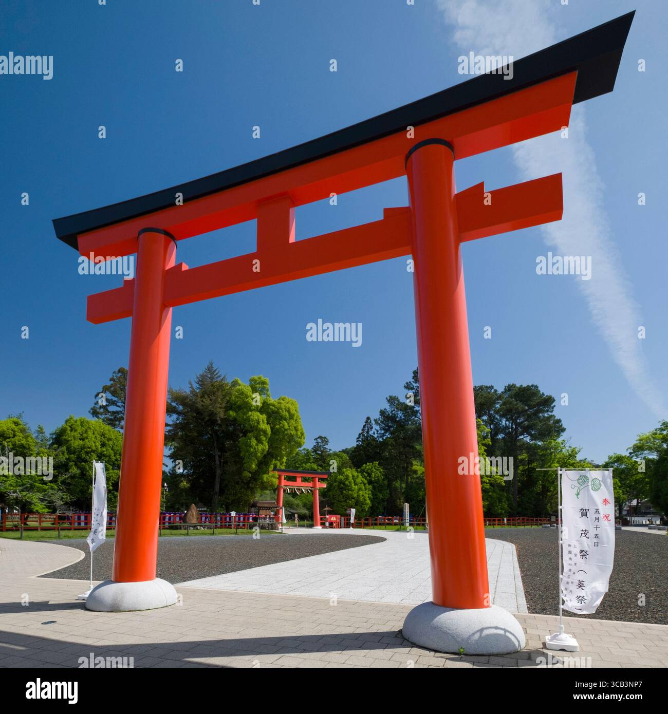 A vibrant red torii gate stands majestically against a clear blue sky, Kamigamo-jinja Shrine ...