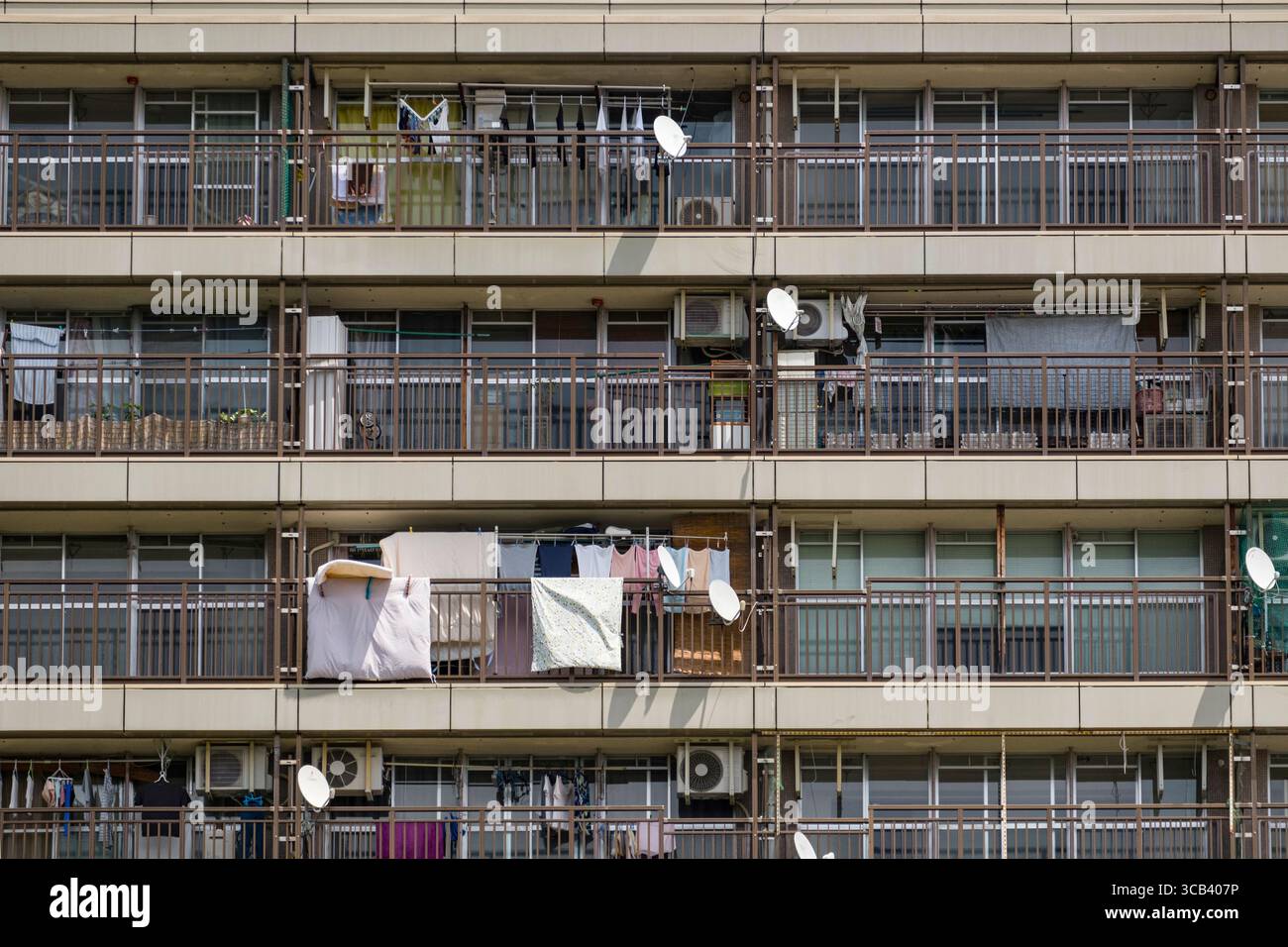 A city apartment building with multiple balconies featuring hanging ...