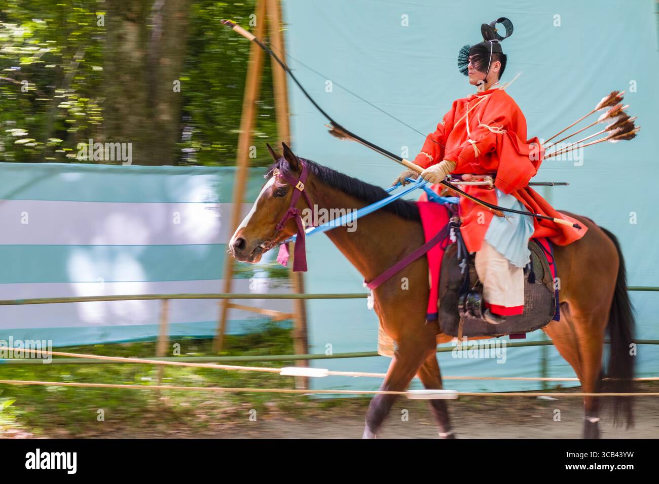 A traditional Japanese archer in vibrant attire performs Yabusame, an ...