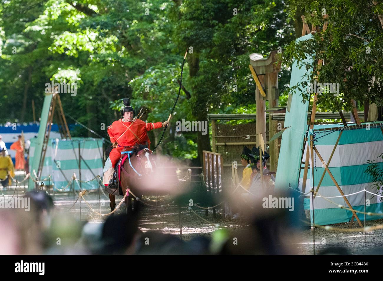 A skilled archer in traditional Japanese attire shoots an arrow while ...