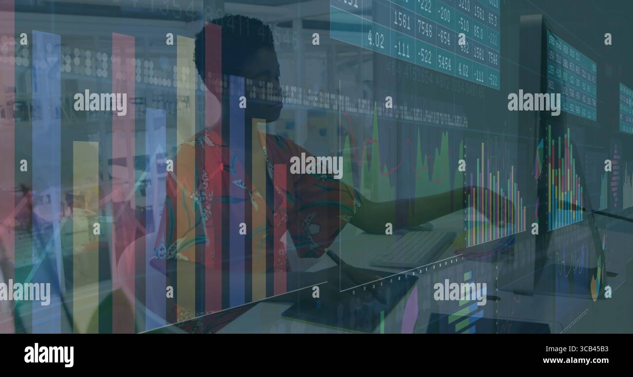 Analyst typing on keyboard using trackpad with laptop monitors and ...