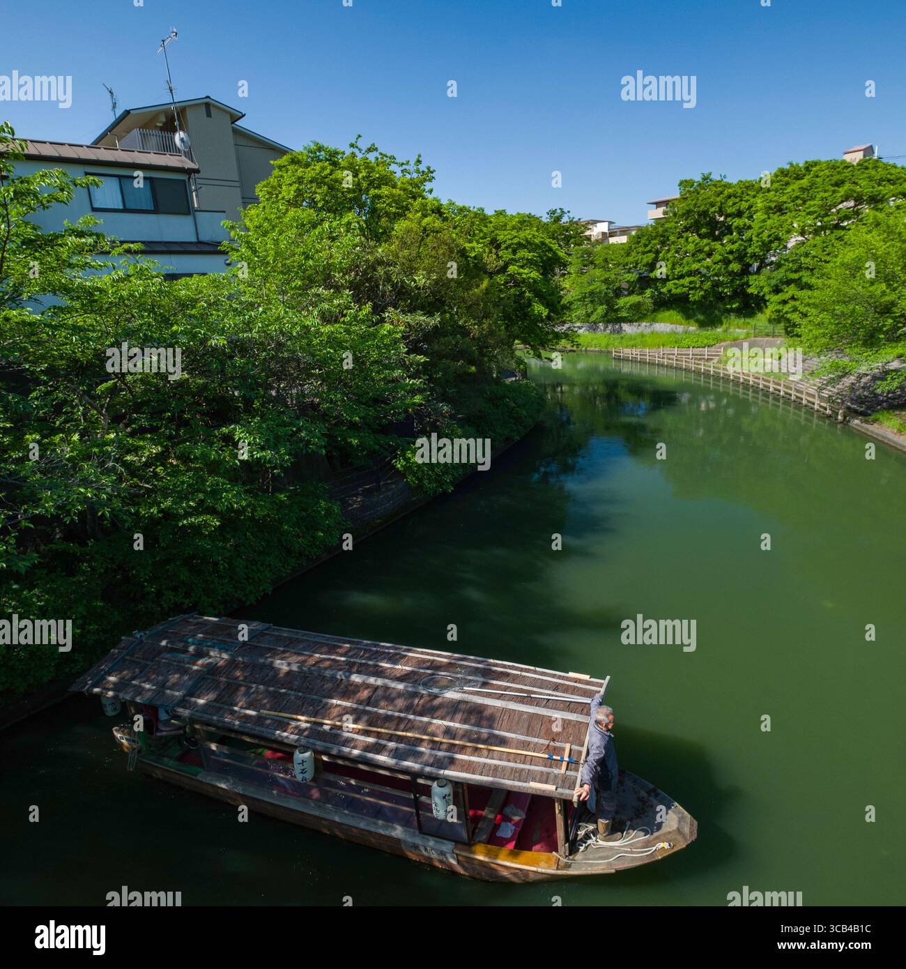 A tranquil river setting featuring a Jikkokubune flat-bottomed boat on ...