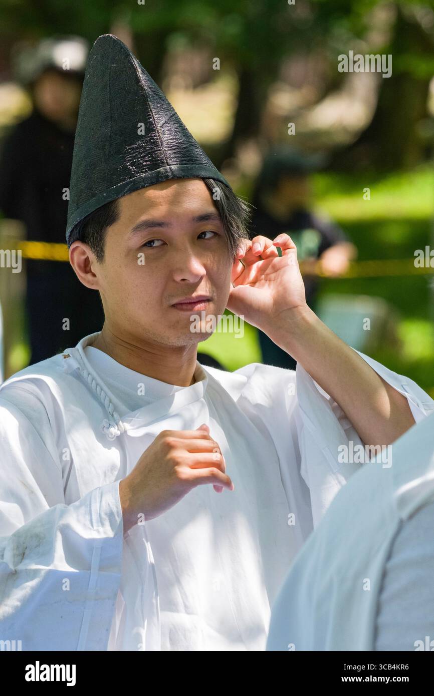 A man wearing traditional Japanese ceremonial attire is seen adjusting ...