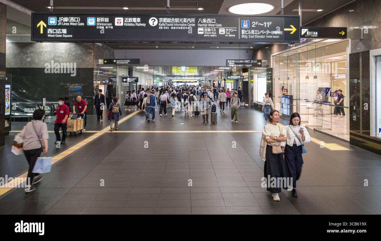 A bustling Kyoto Station filled with diverse commuters. The scene ...