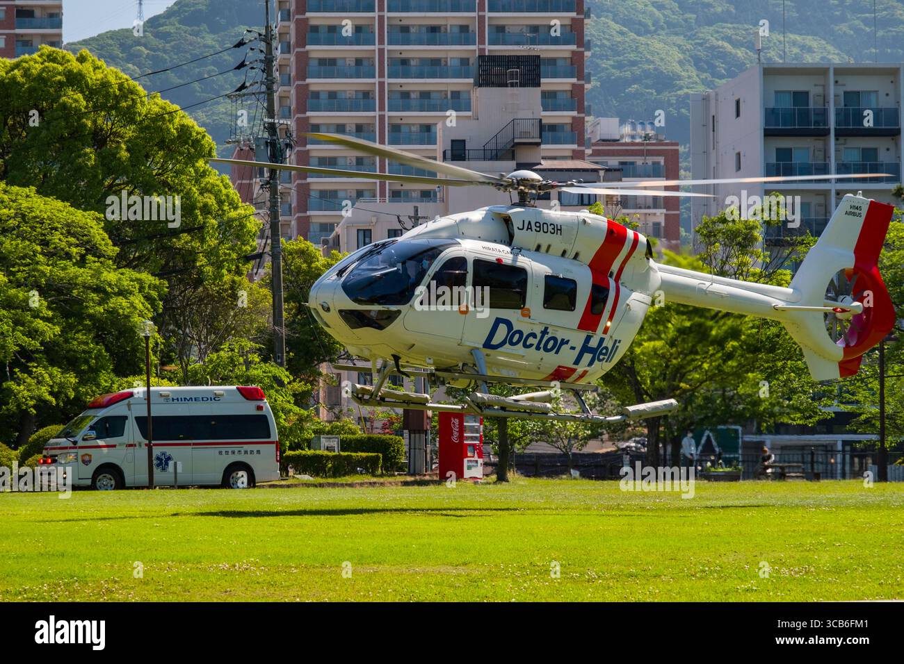 A medical helicopter, labeled Doctor-Heli, descends near an ambulance ...