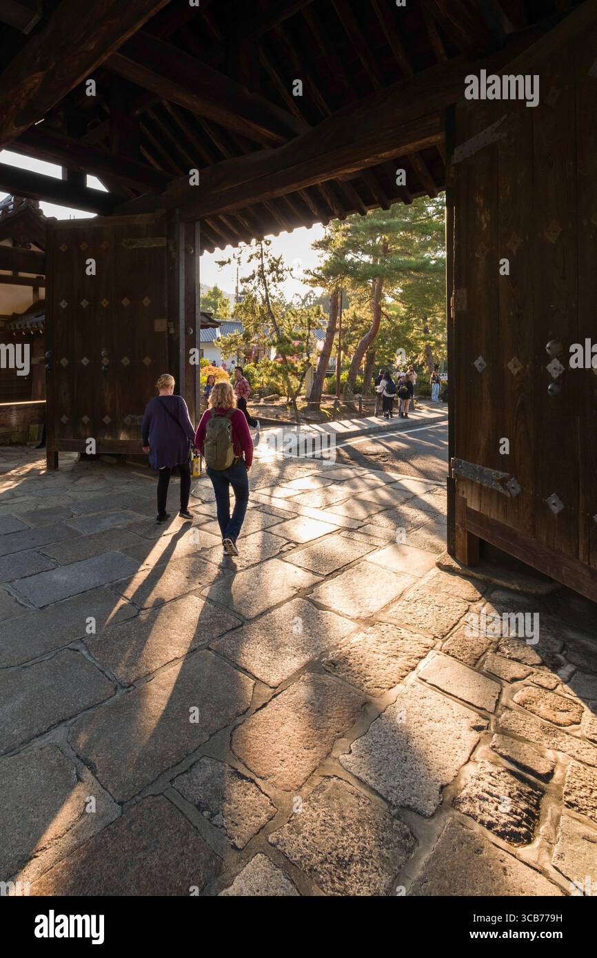 Two people walk through Nanzenji Sammon Gate surrounded by natural ...