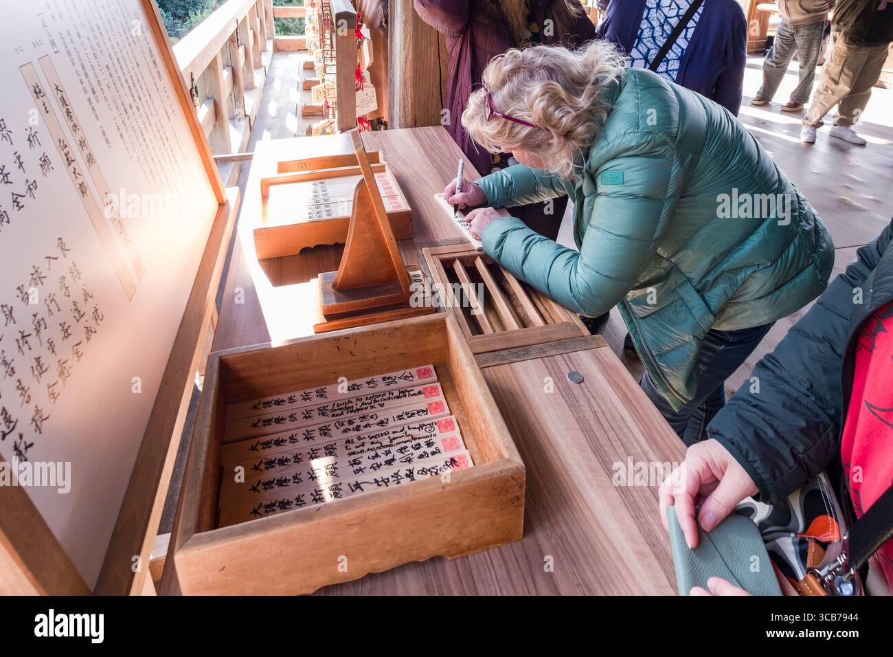 Visitor placing handwritten prayers on wooden blocks at Kiyomizu-dera ...